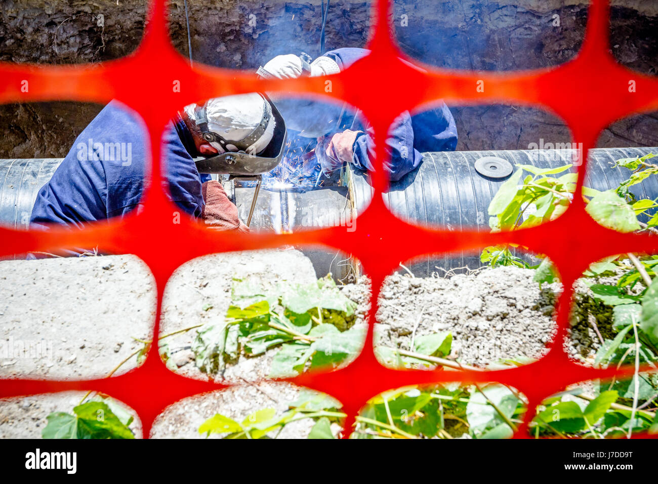 Welders are in trench they arc welding pipeline. Confined space with ...