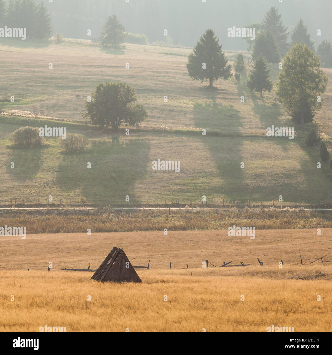 Old log cabin and fields in mountain Stock Photo - Alamy