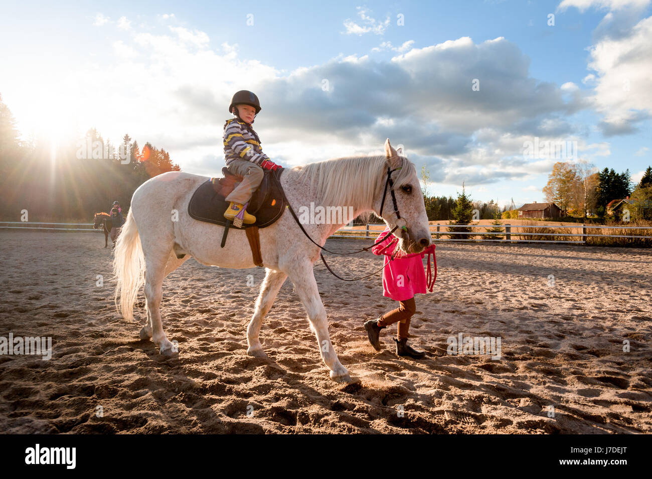 Little child riding with a pony Stock Photo - Alamy