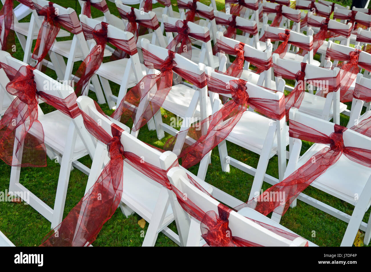 White wedding chairs with red sashes Stock Photo - Alamy