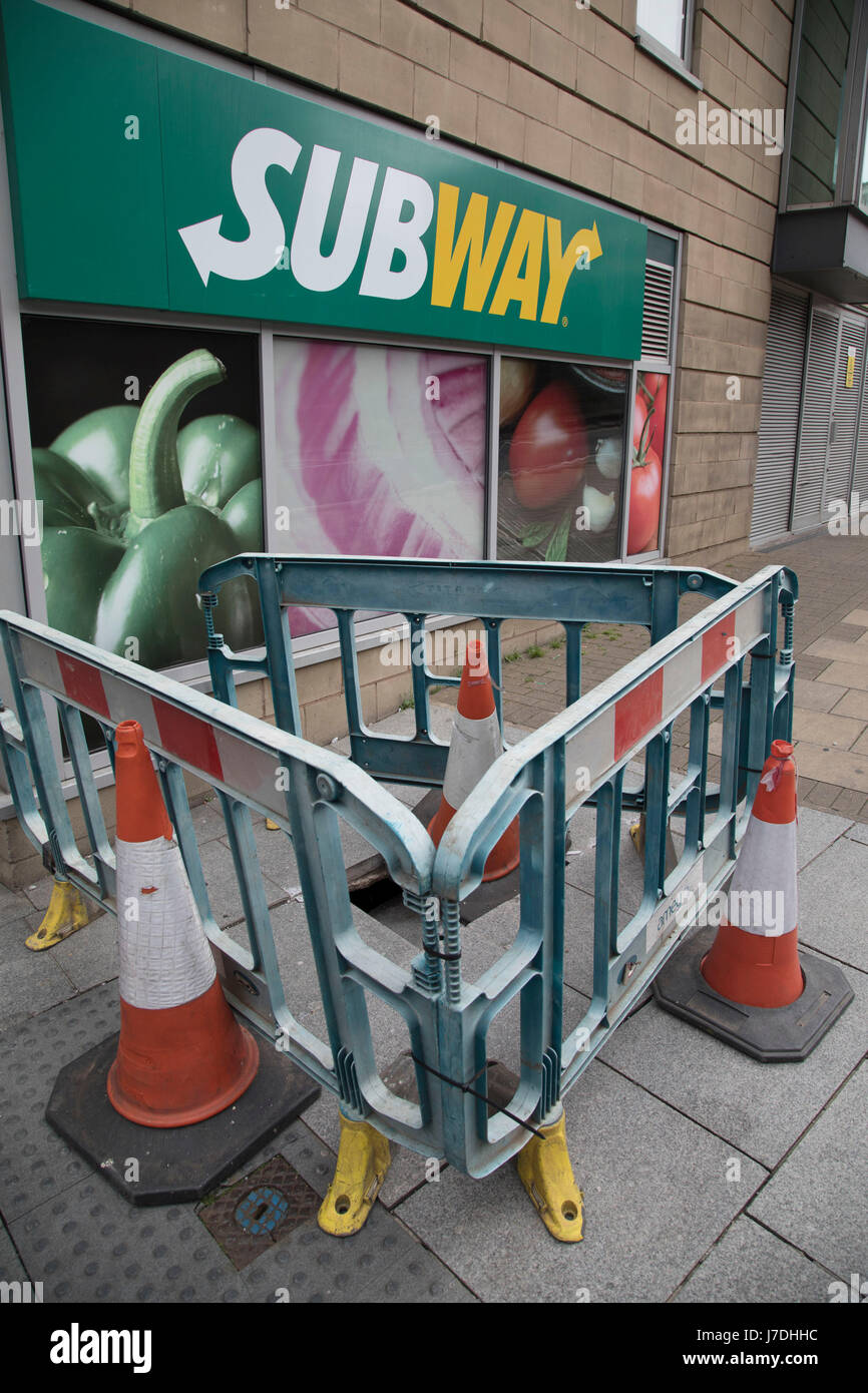 Hole in the pavement is cordoned off to be fixed with warning bariers ...