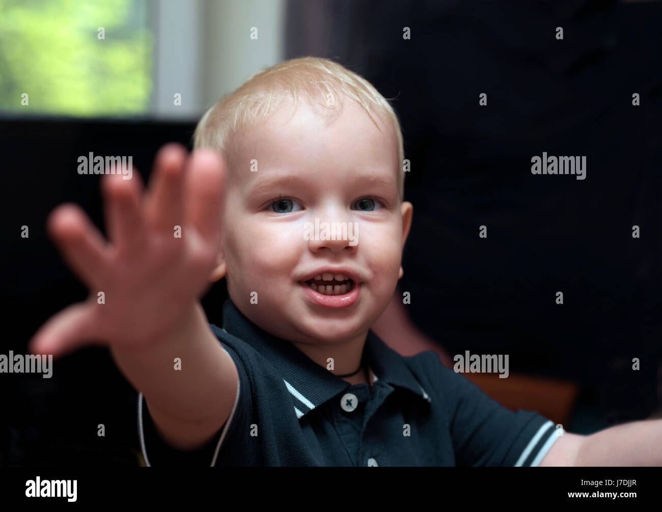 A little boy with blonde hair reaching hand asking for help or ...