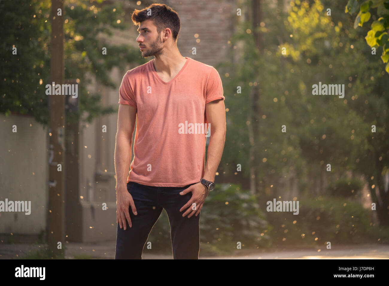 one young man, standing portrait, outdoors, sunny day, looking sideways ...
