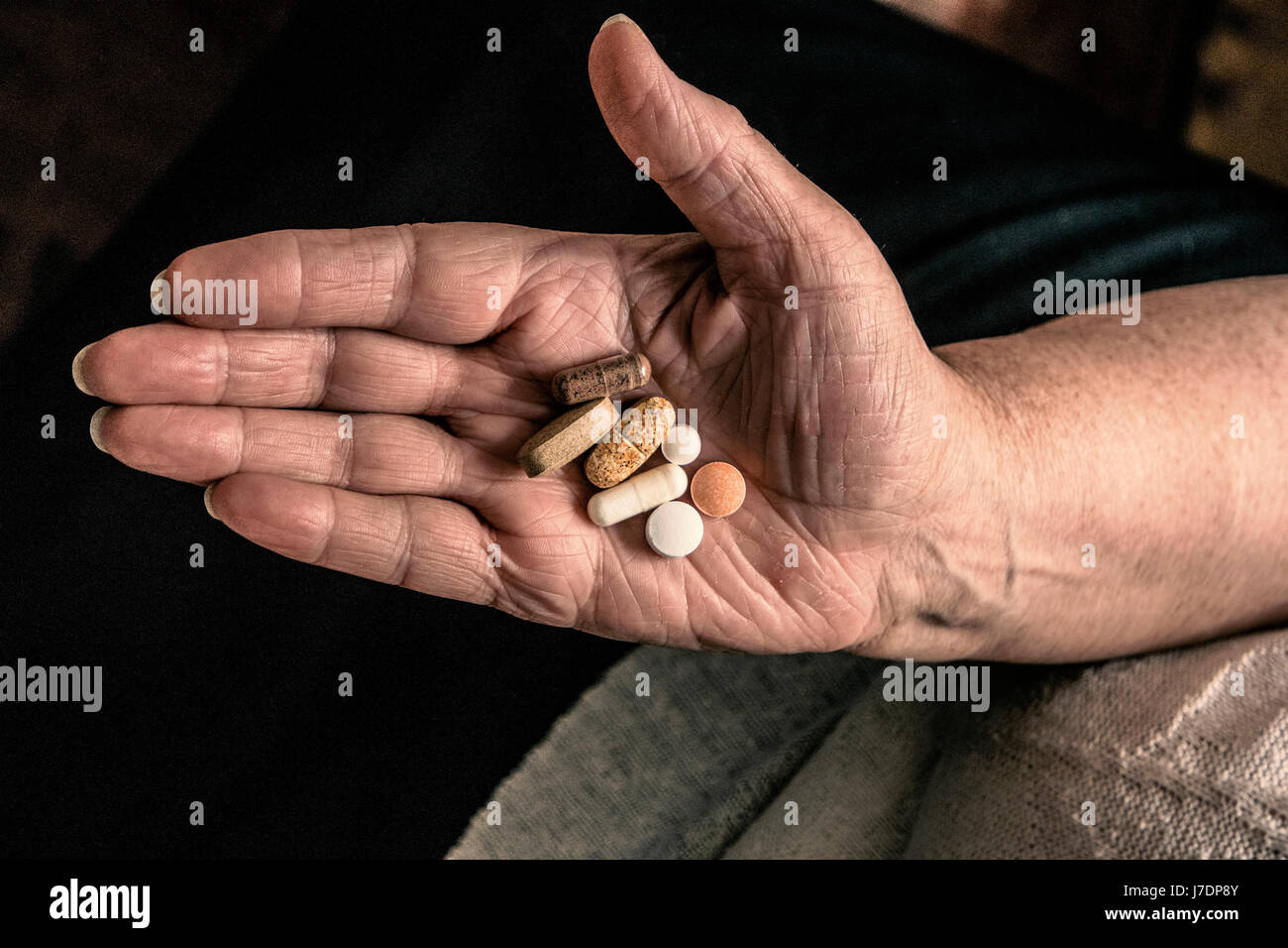 Above view of pills and tablets on senior woman palm vintage toned ...