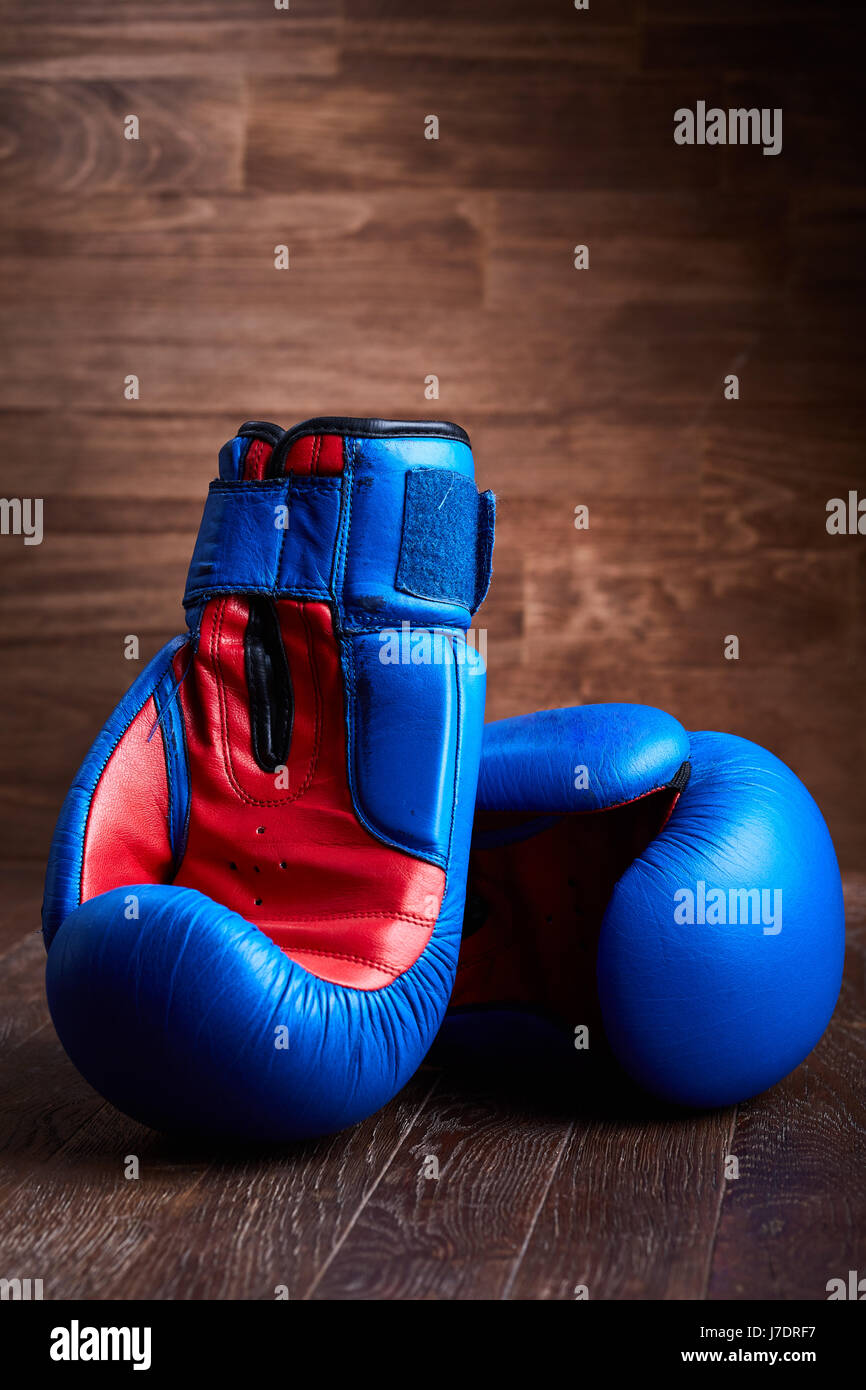 Boxing backgrounds with two blue and red gloves on the wooden plank ...