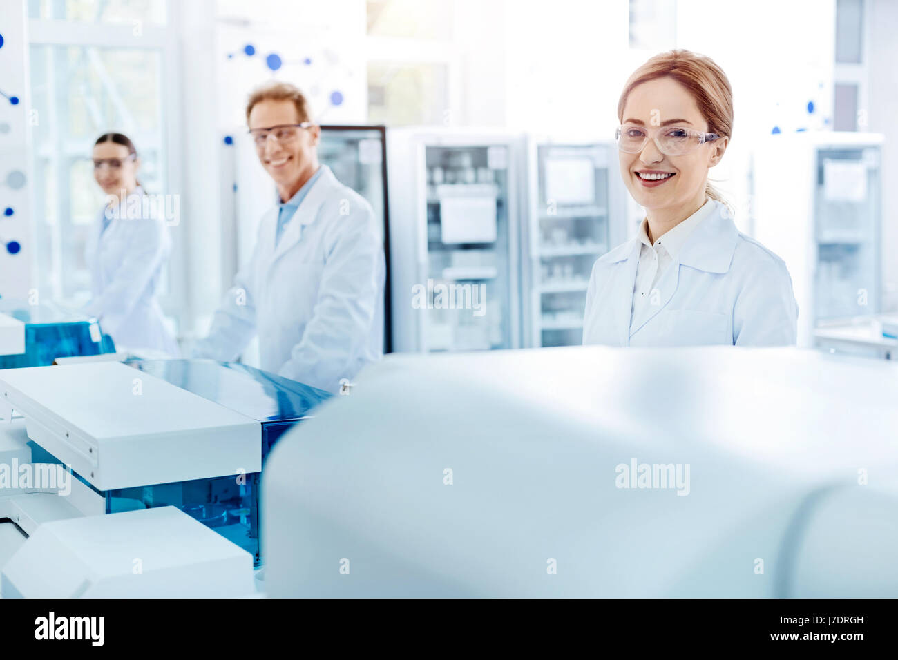 Three scientists posing in one line Stock Photo - Alamy