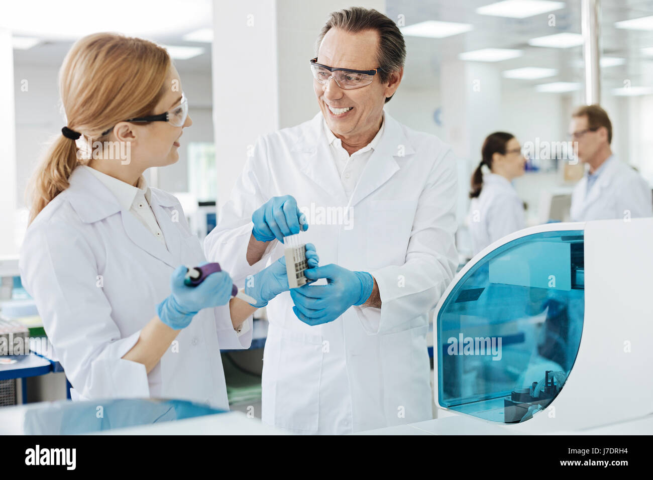 Handsome scientist holding set with tubes Stock Photo - Alamy