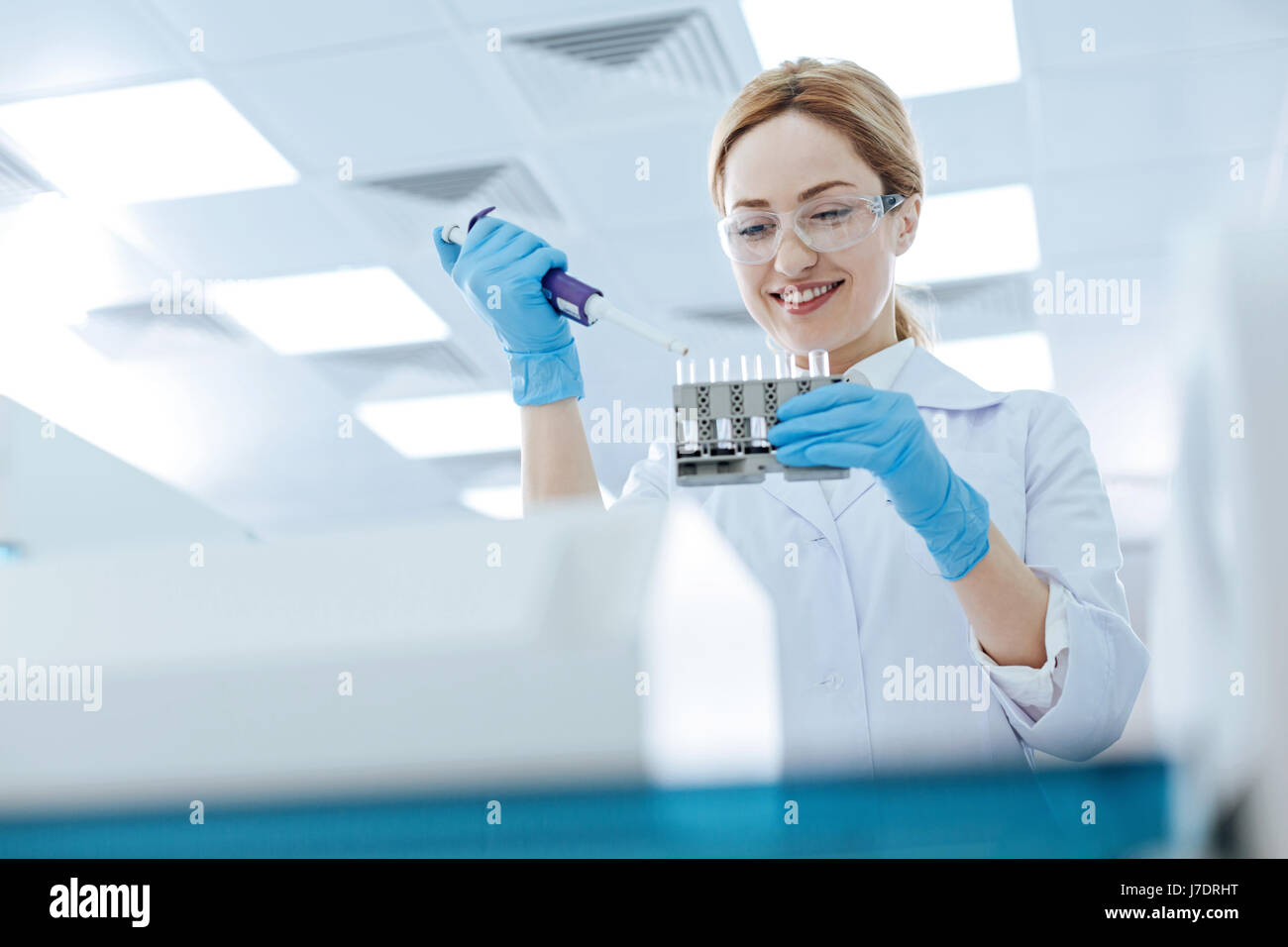 Positive young woman working chemical laboratory Stock Photo - Alamy