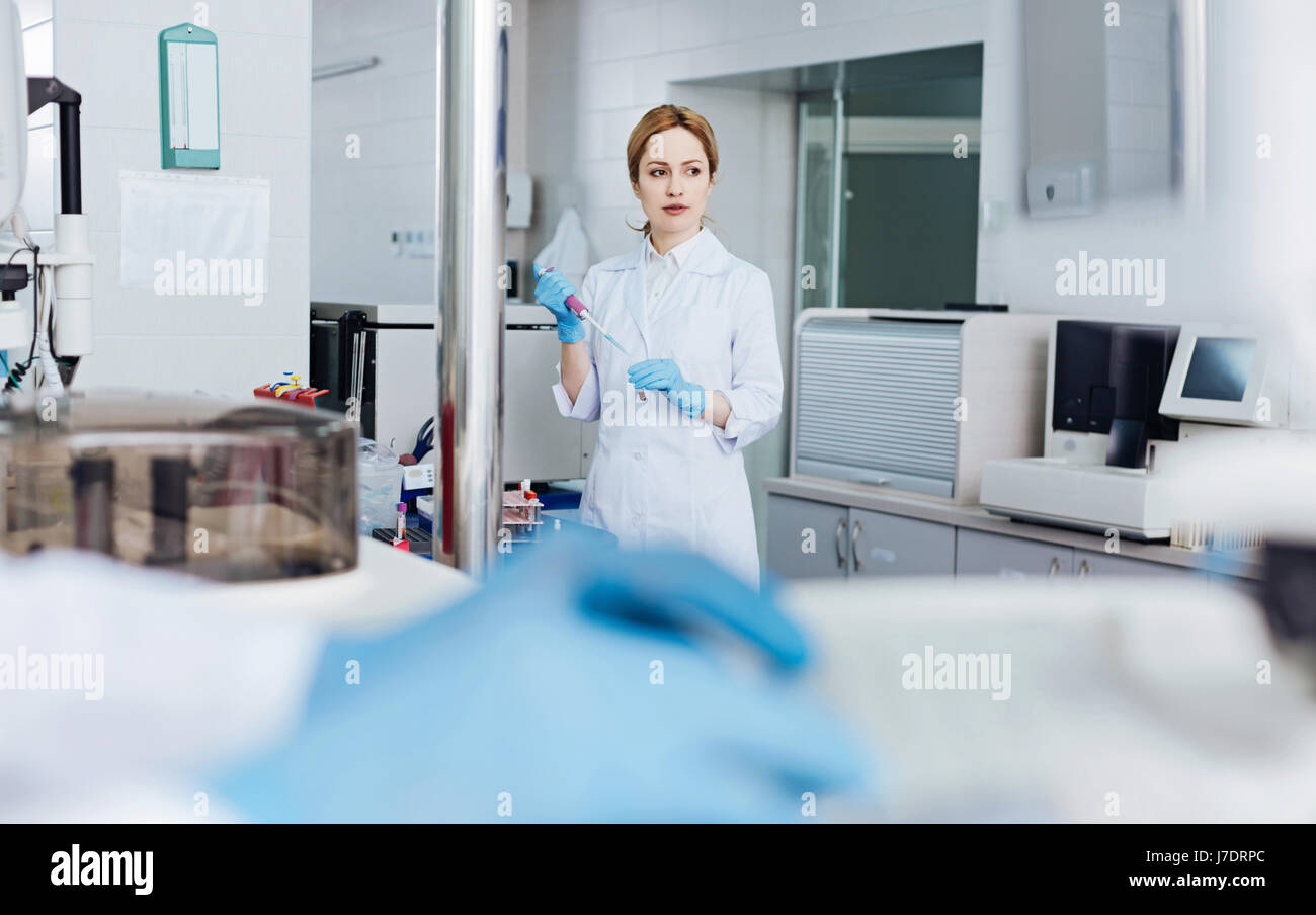Thoughtful female researcher looking sideways Stock Photo - Alamy