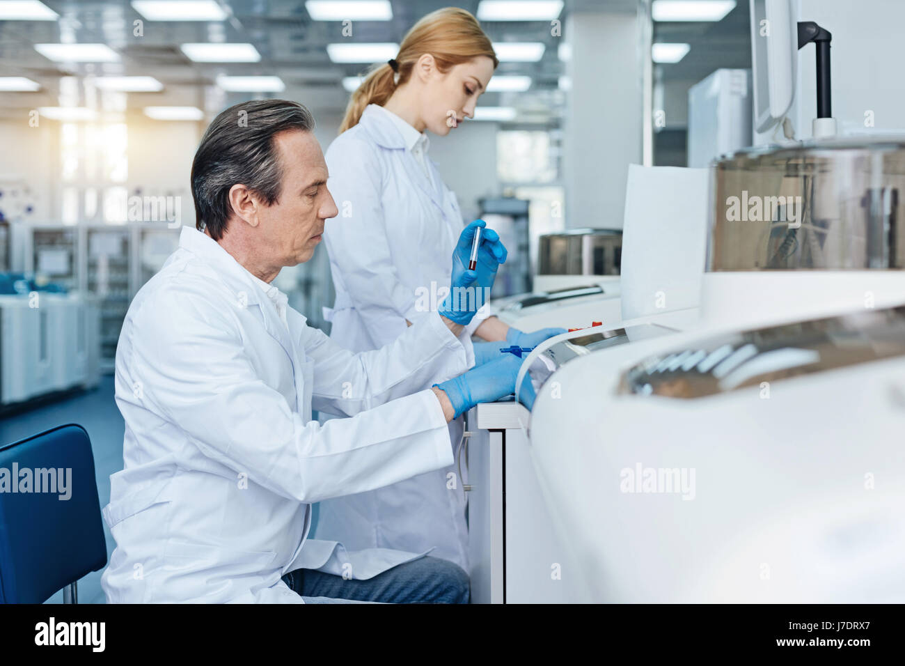 Serious technician doing blood analysis Stock Photo - Alamy