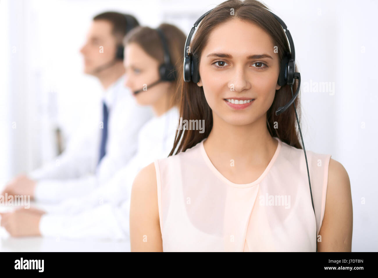 Call center operators. Focus at young beautiful business woman in headset Stock Photo - Alamy
