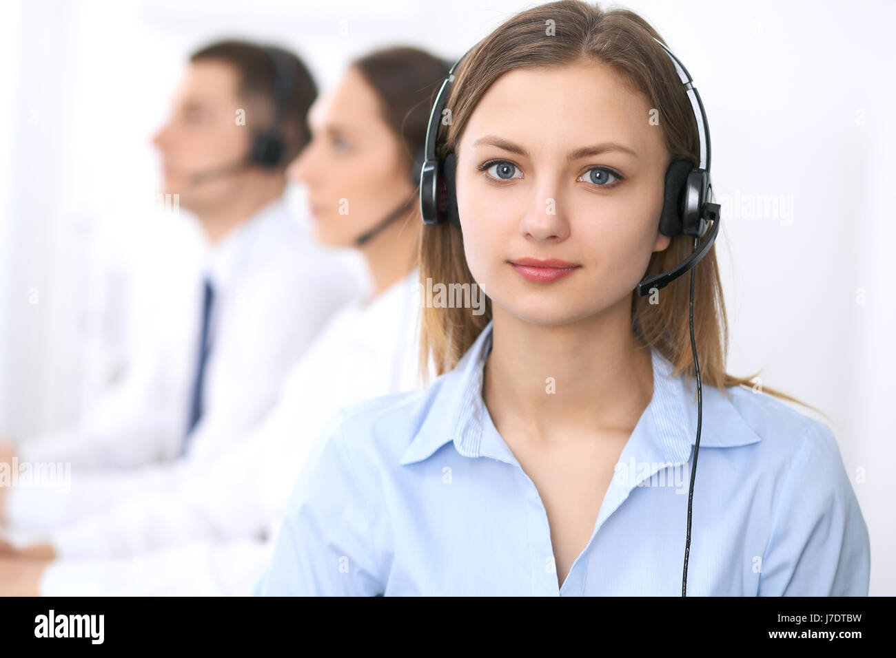 Call center operators. Focus at young beautiful business woman in headset Stock Photo - Alamy