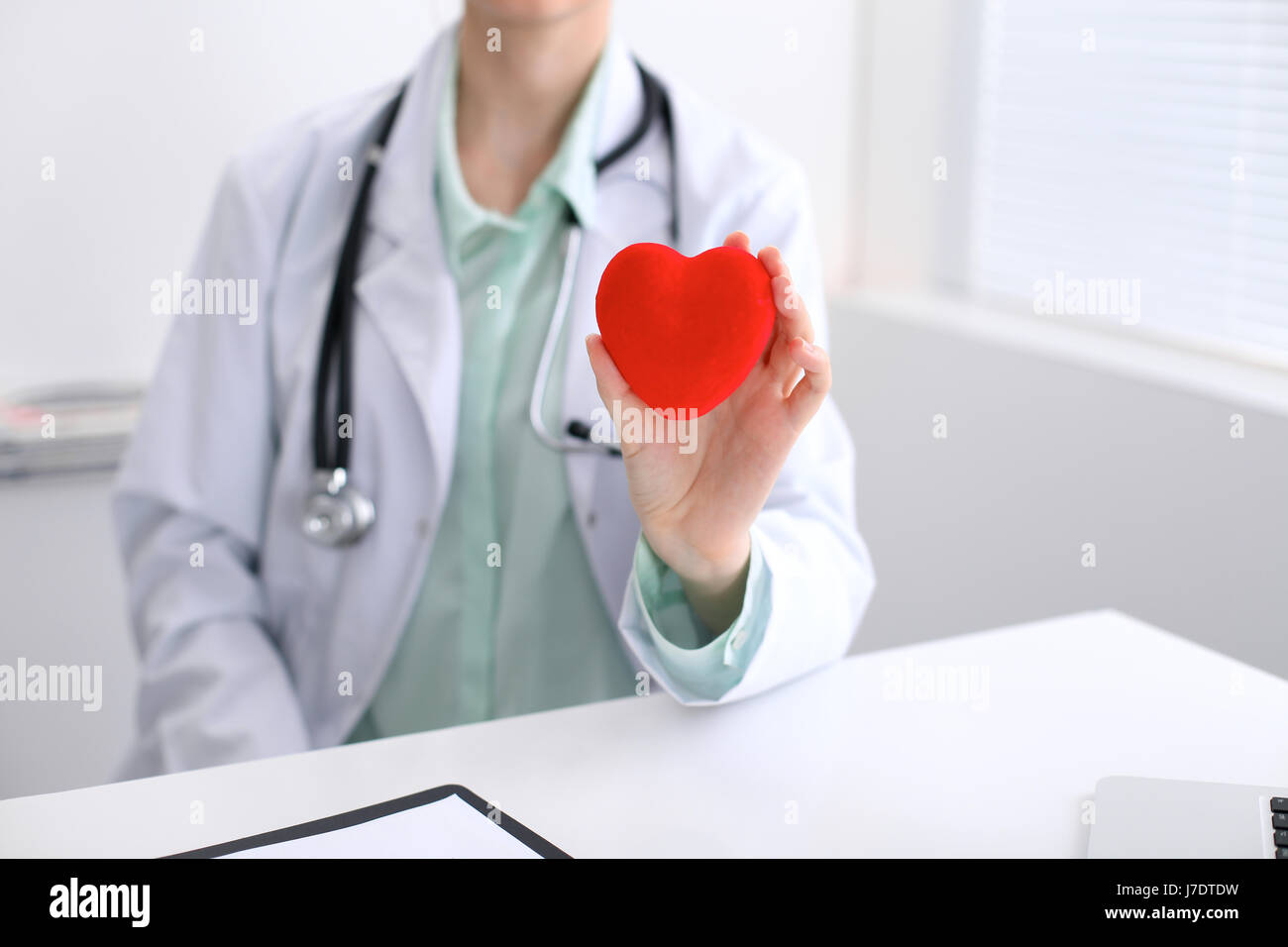 Female doctor with stethoscope holding heart. Cardio therapeutist ...
