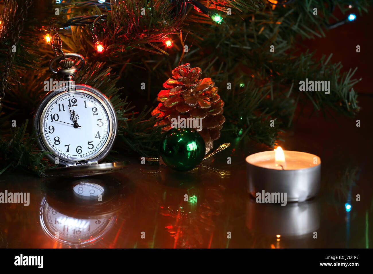 Vintage pocket watch near Christmas tree and lighting candle Stock ...