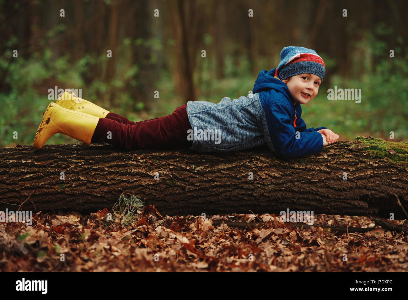 little funny boy on big log Stock Photo - Alamy