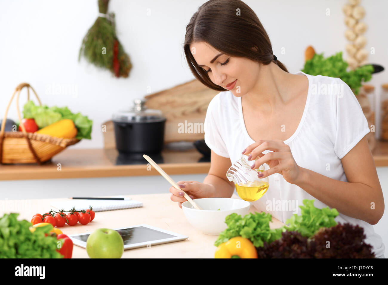 Beautiful Hispanic woman is cooking in the kitchen Stock Photo - Alamy