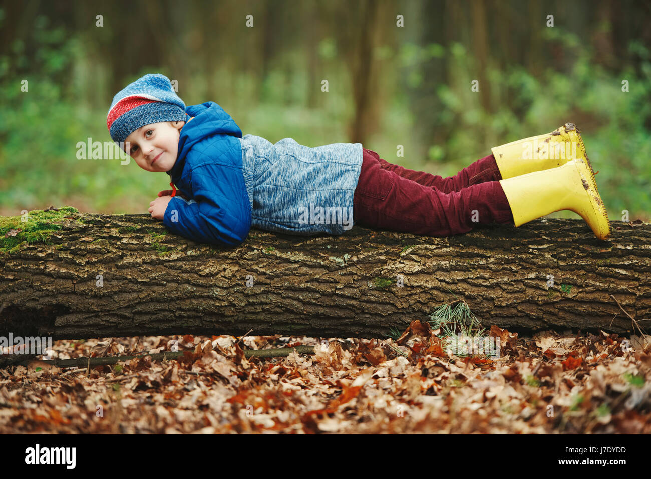 little funny boy on big log Stock Photo - Alamy