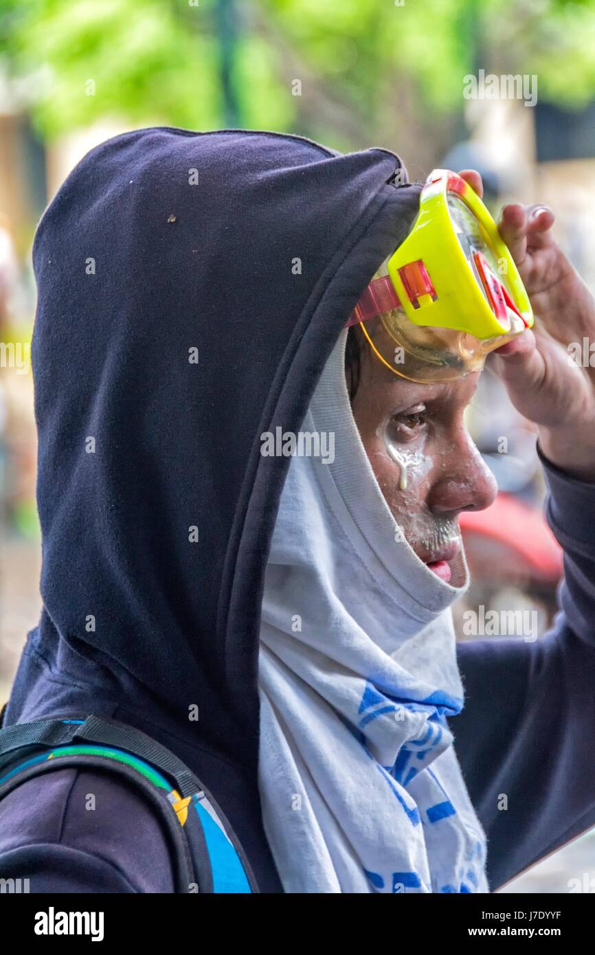 A young man lifts a diving mask, used to protect his face against the ...