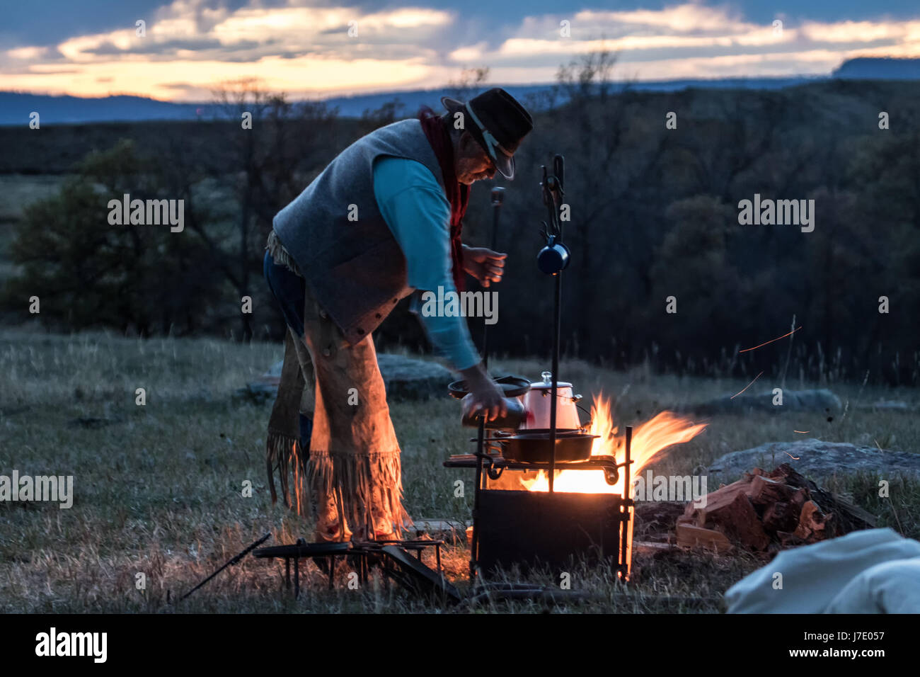 Cowboy tending camp fire Stock Photo - Alamy