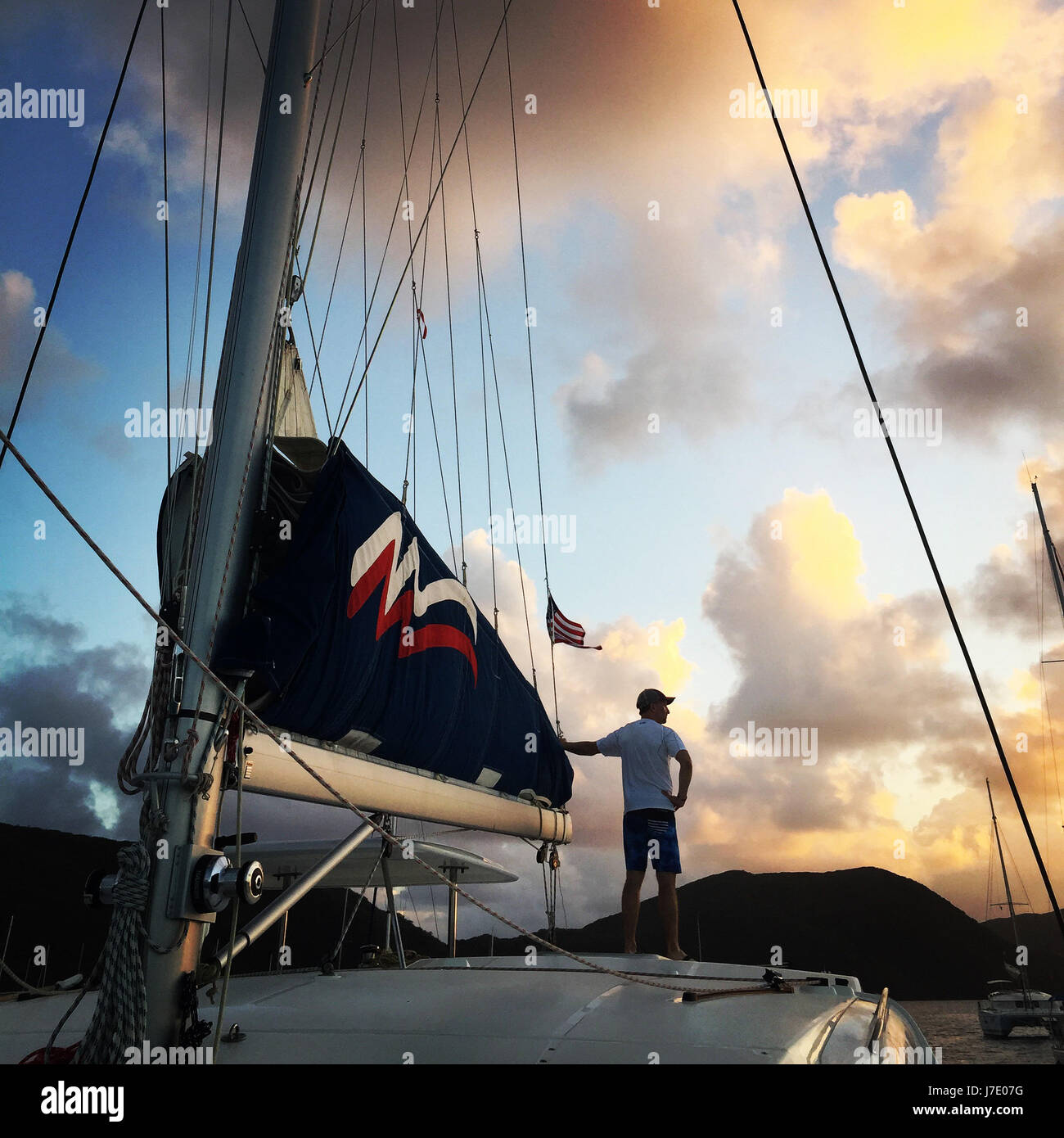 captain resting at sunset after sailing a catamaran in the british ...
