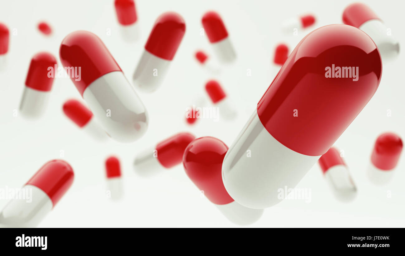 Pills falling on a white background Stock Photo - Alamy