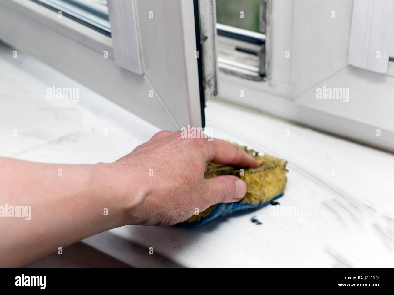 Male hand cleaning a window sill covered with dirt and dust, indoor ...
