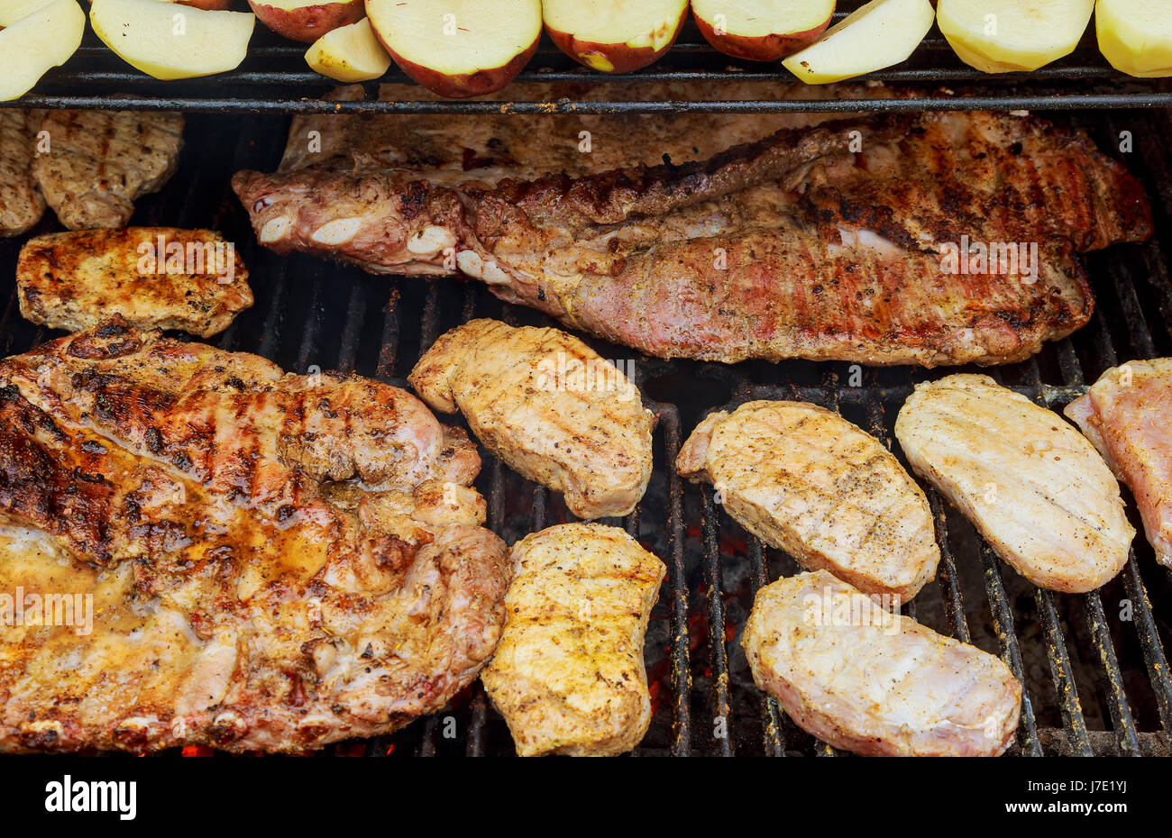 Ribs on the grill with flames Fire charcoal barbecue pigs ribs steaks ...