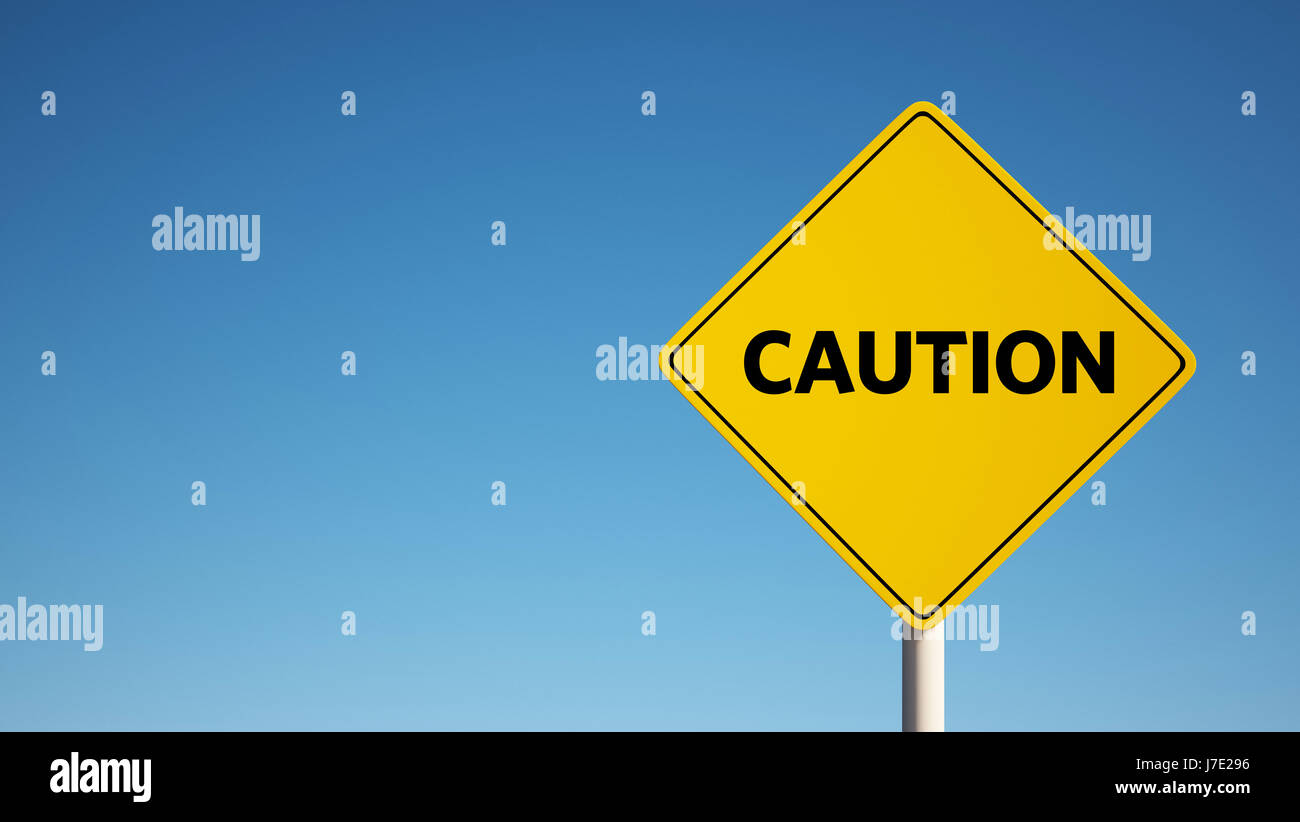 Caution Sign isolated on clean blue sky Stock Photo - Alamy