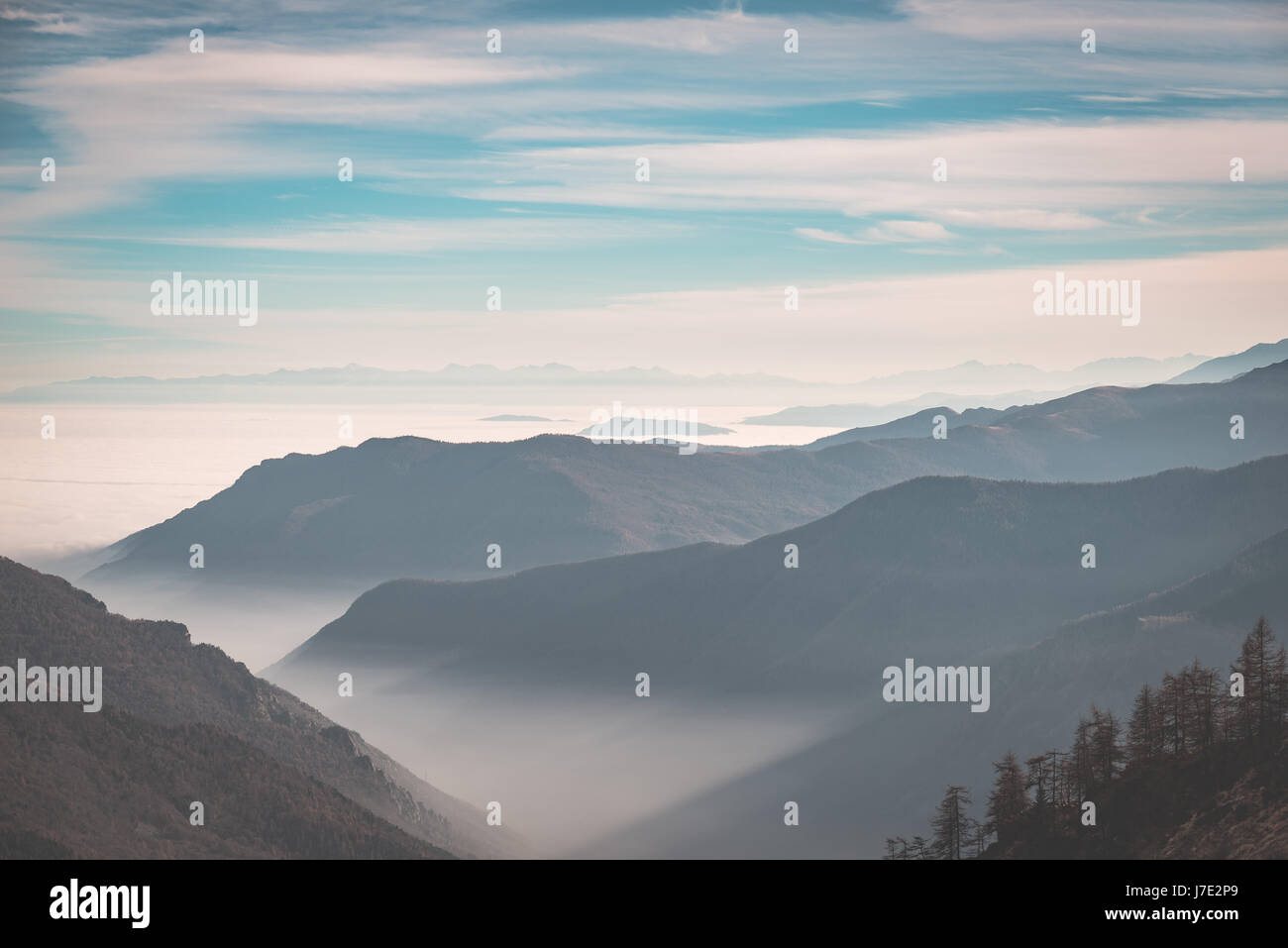 Distant mountain range with fog and mist covering the valleys below ...