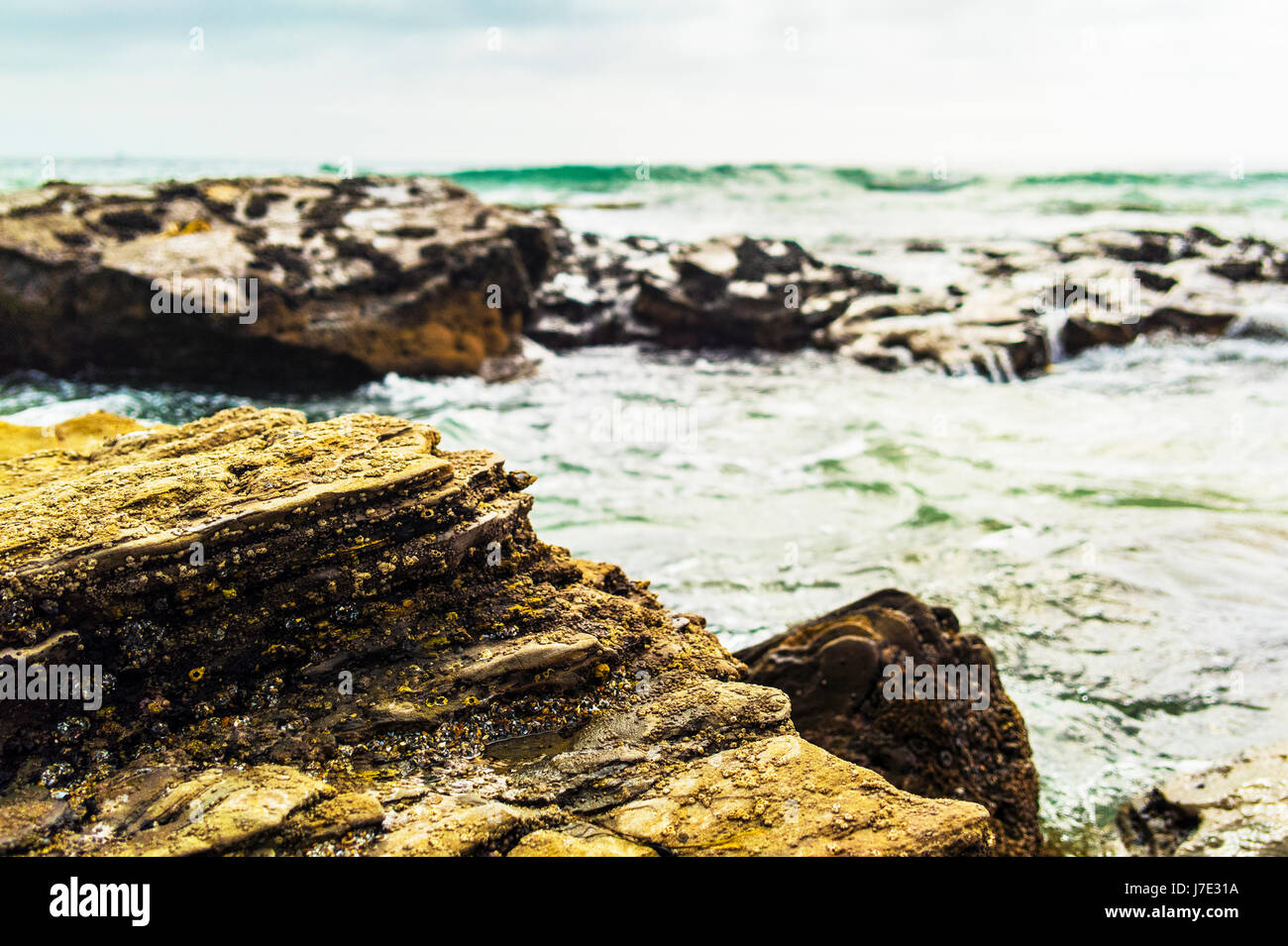 Boulder rocks overlooking beach shoreline Stock Photo - Alamy