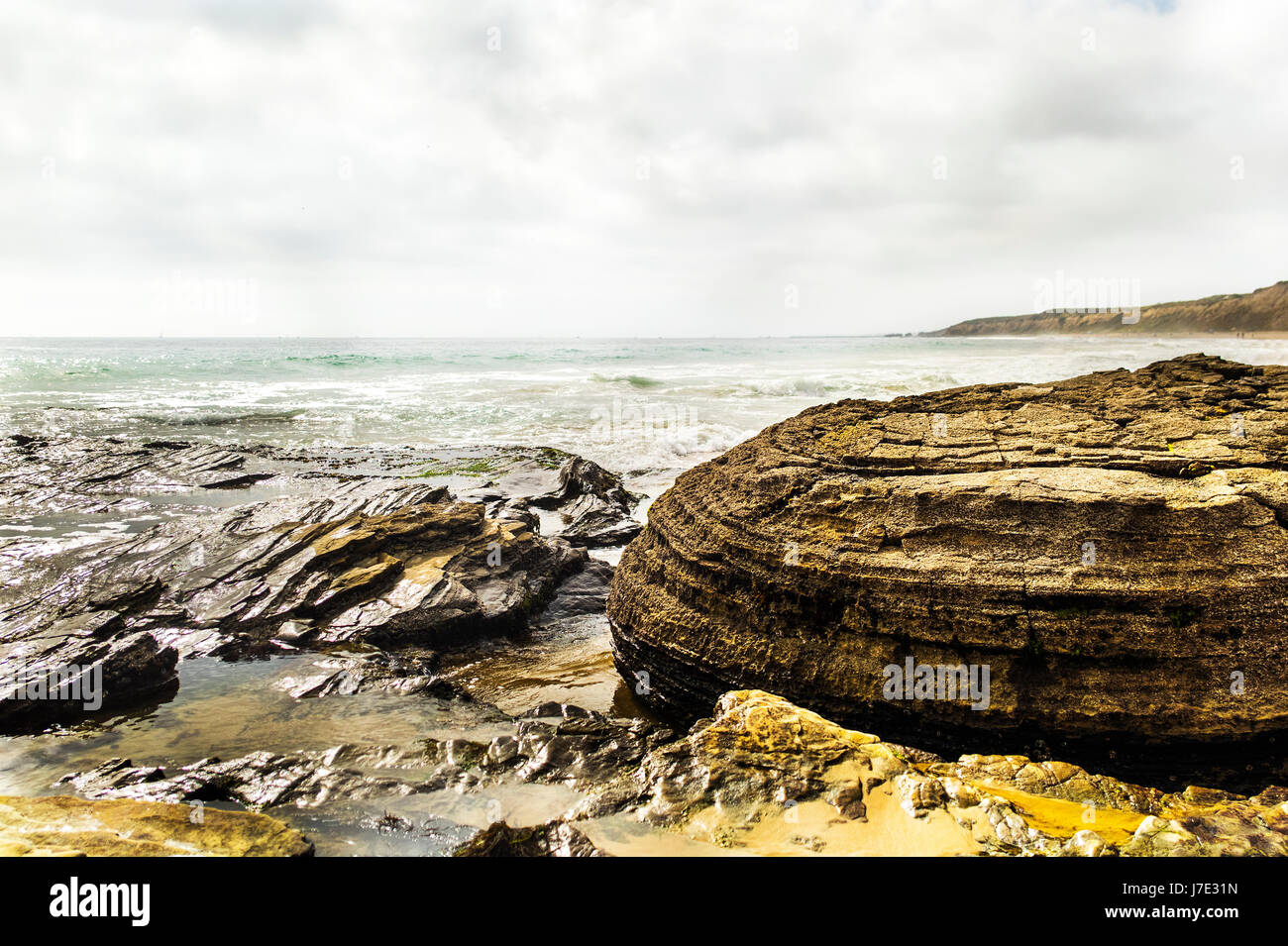 Boulder rocks overlooking beach shoreline Stock Photo - Alamy