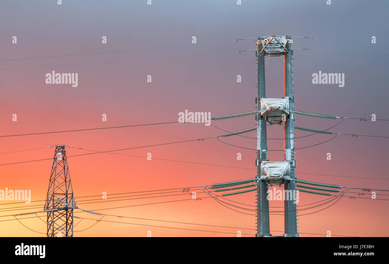 High voltage power transmission line on sunset background Stock Photo ...