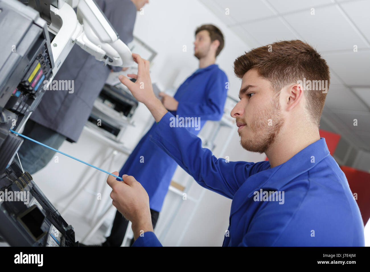 Maintenance man working on photocopier Stock Photo - Alamy