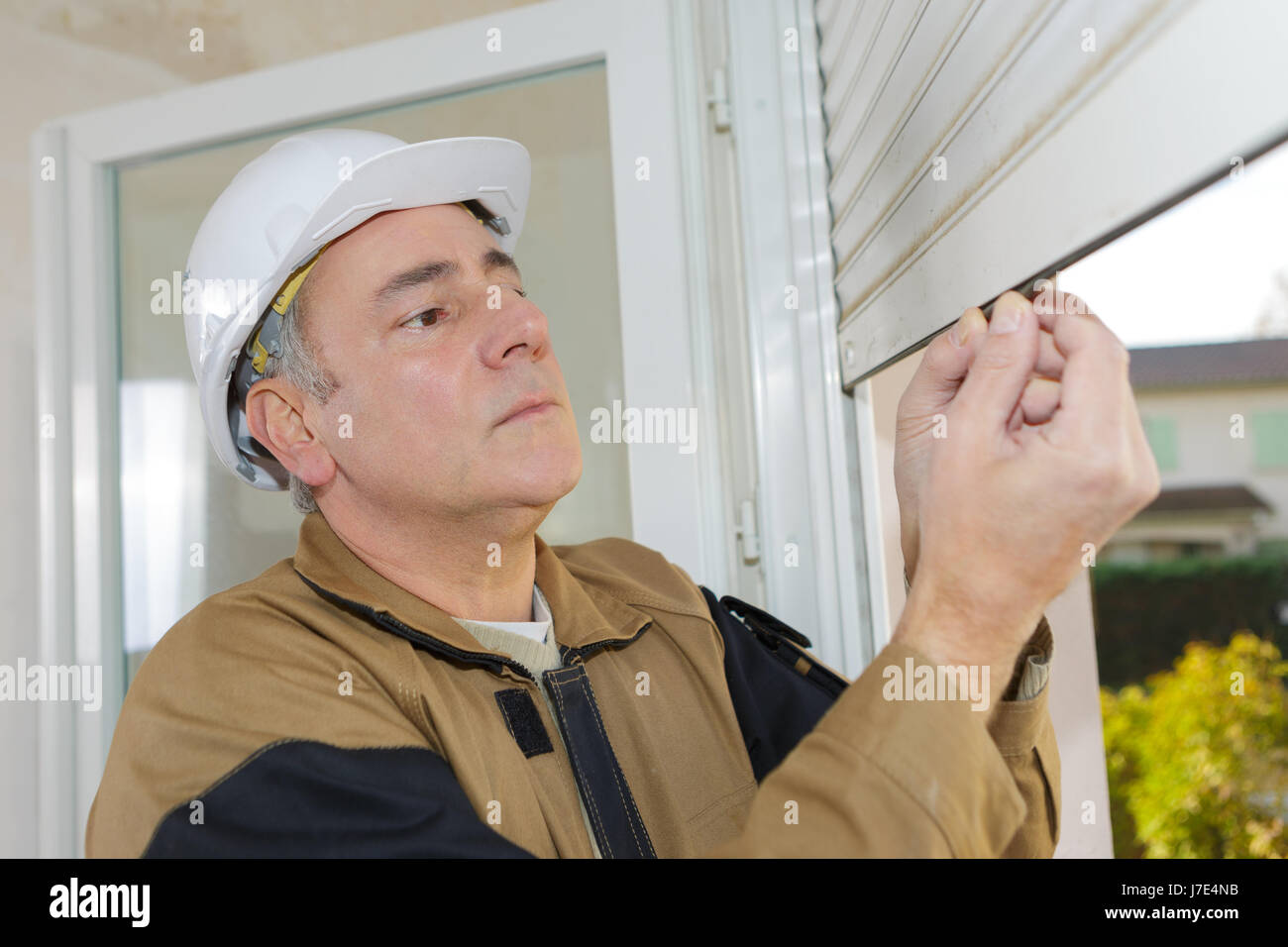 builder installing shutters Stock Photo - Alamy