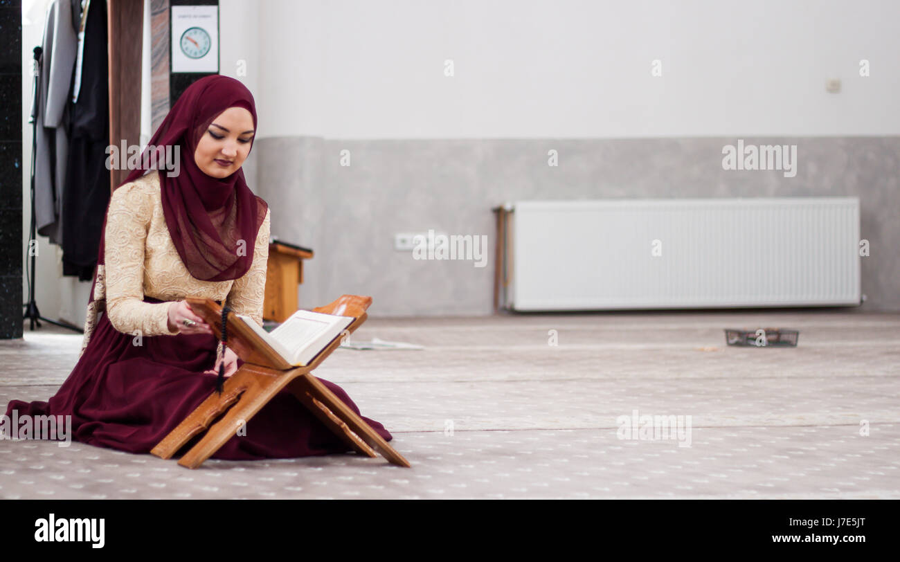 Young and beautiful girl sitting covered in sumptuous dress and teaches ...