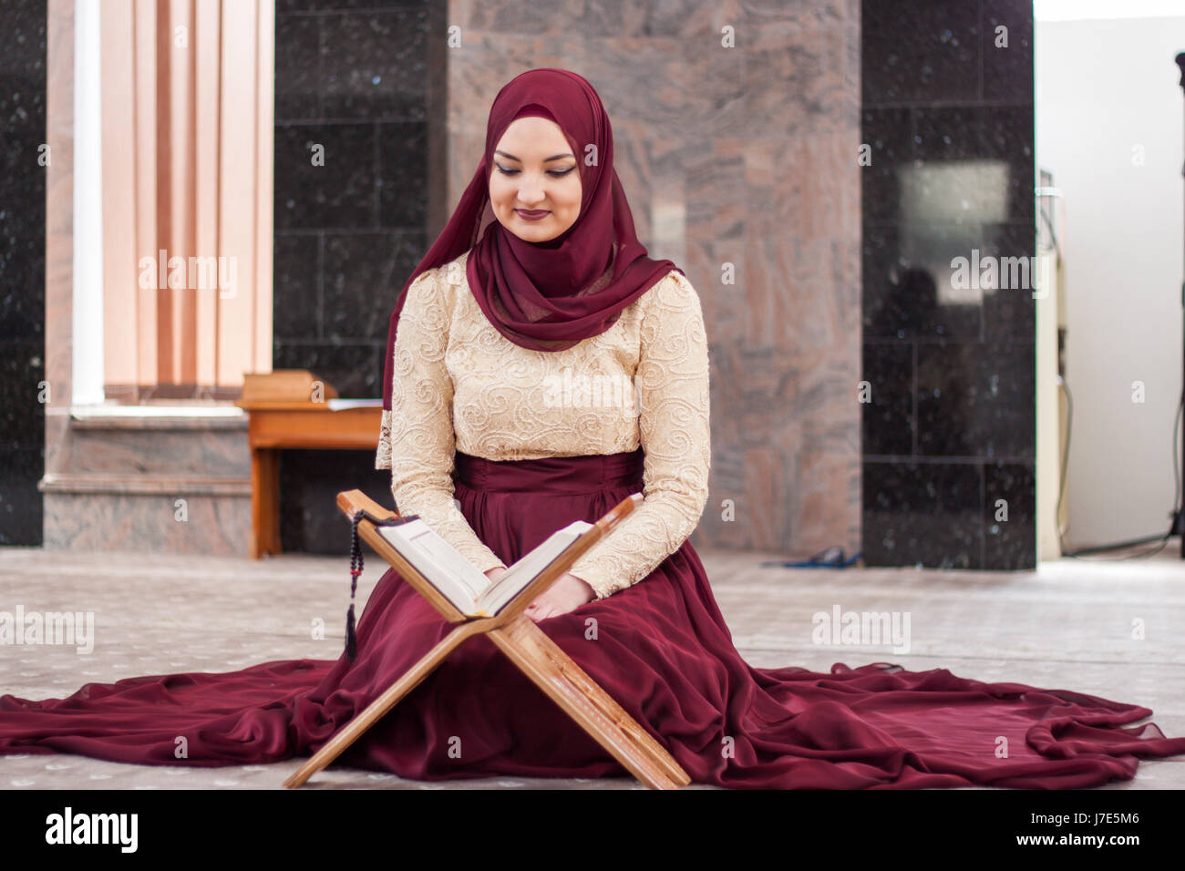 Young and beautiful girl sitting covered in sumptuous dress and teaches ...