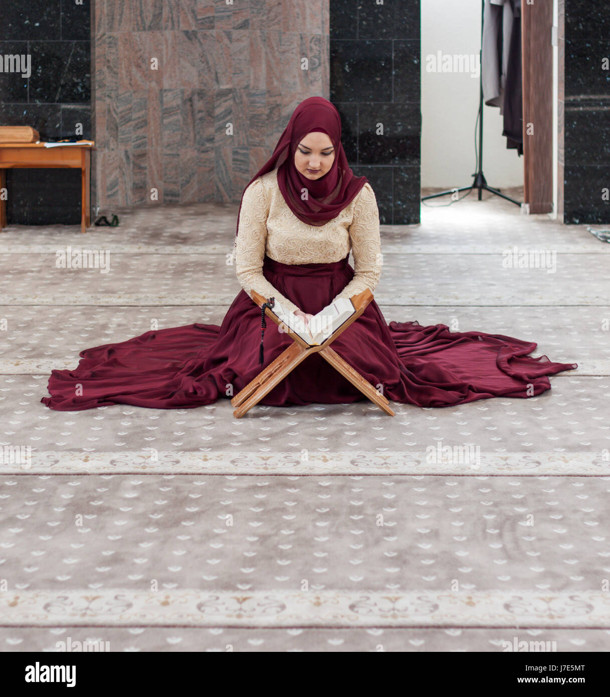 Young and beautiful girl sitting covered in sumptuous dress and teaches ...