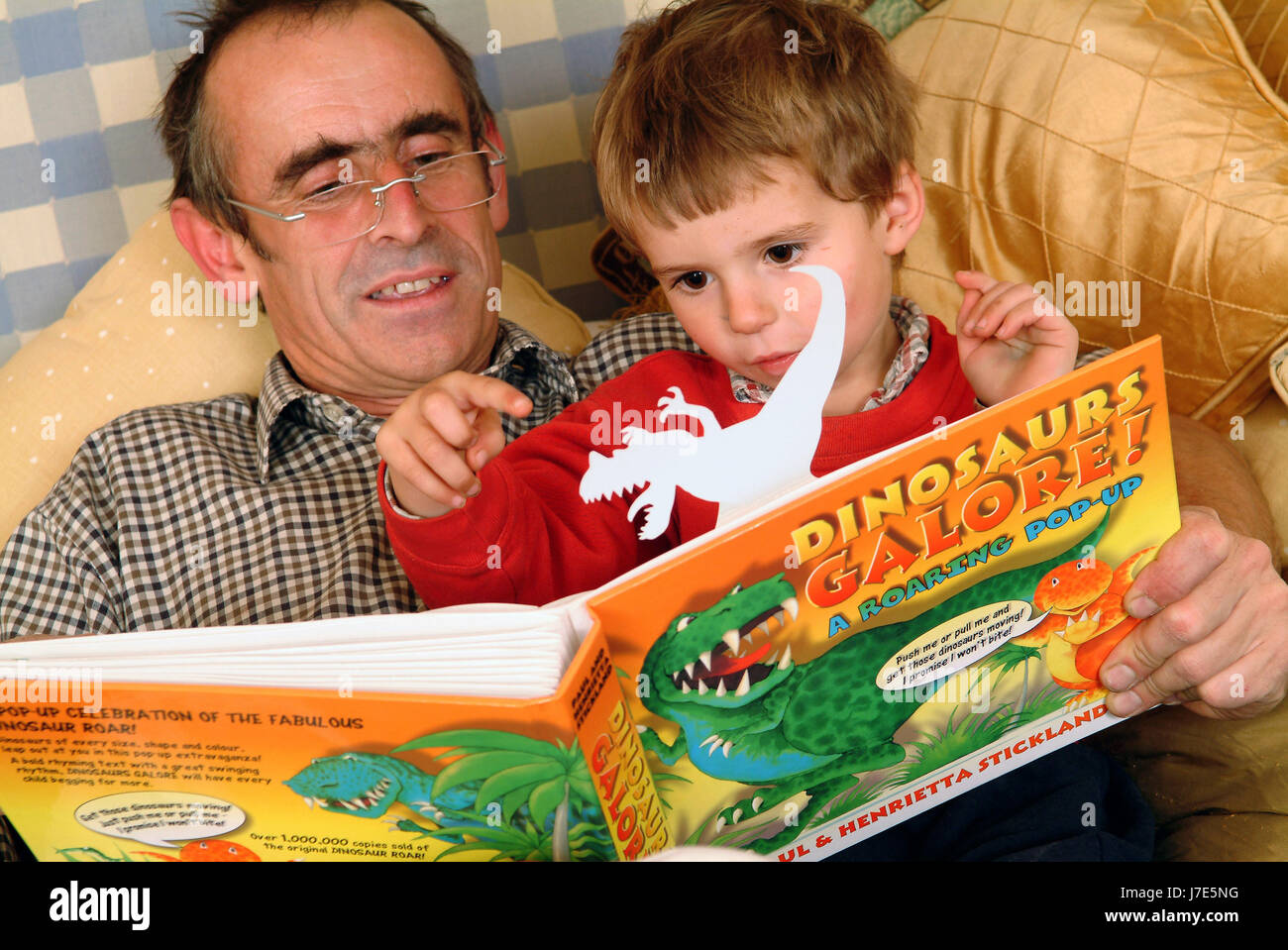 Paul Stickland bedtime reading with children Arthur (3) in red and ...