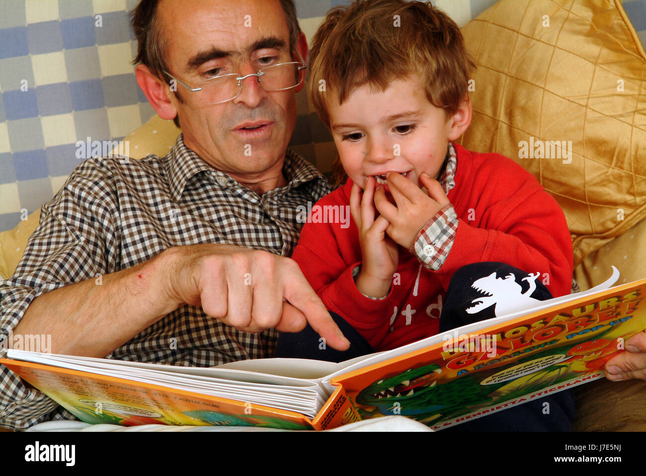 Paul Stickland bedtime reading with children Arthur (3) in red and ...