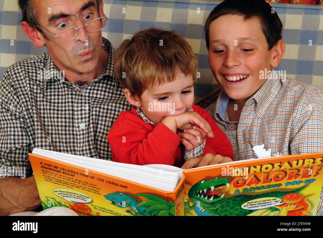 Paul Stickland bedtime reading with children Arthur (3) in red and ...
