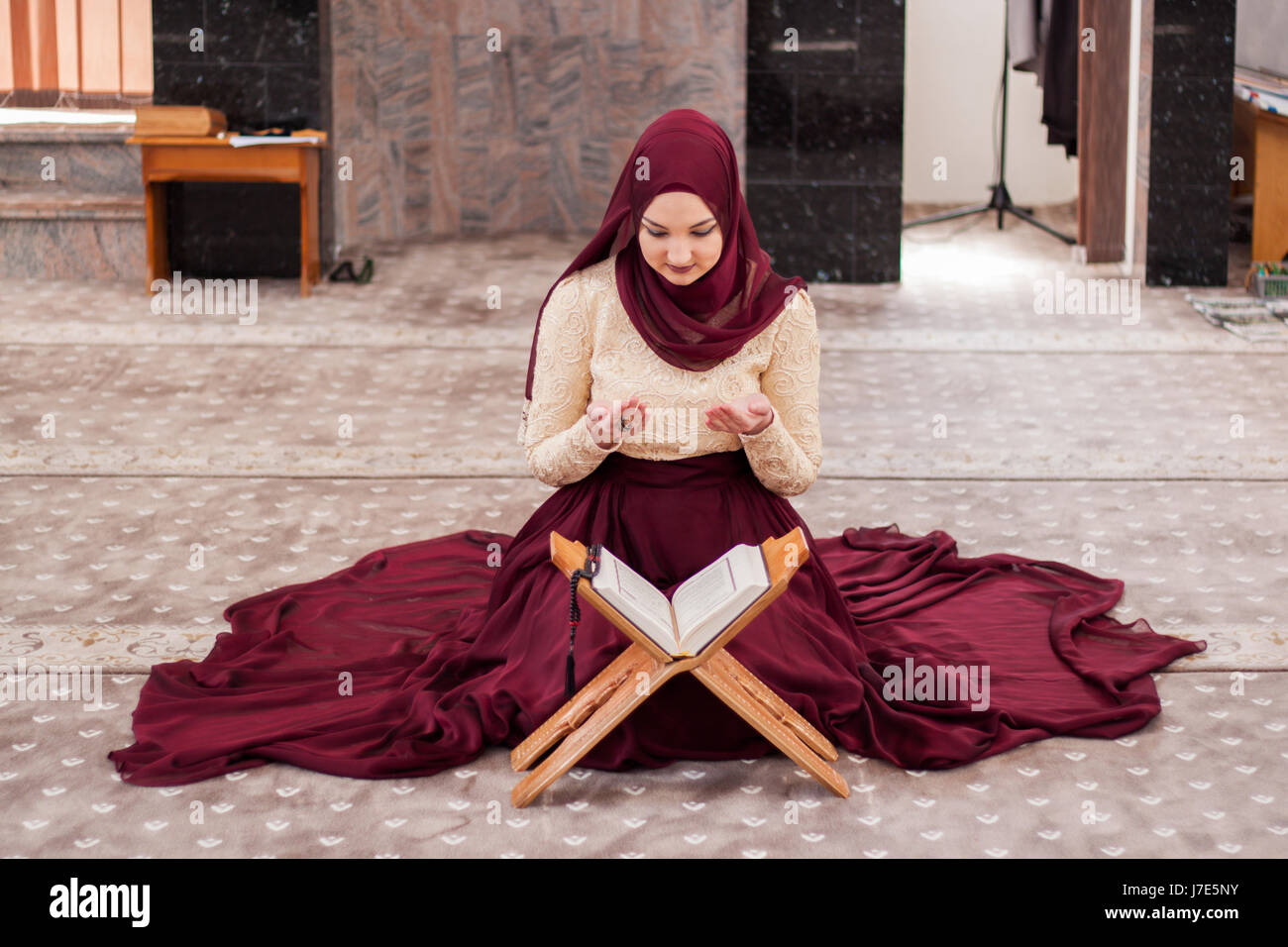 Young and beautiful girl sitting covered in sumptuous dress and teaches ...