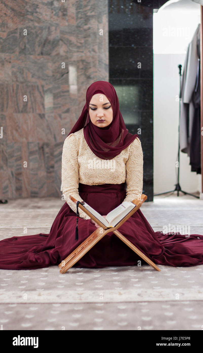 Young and beautiful girl sitting covered in sumptuous dress and teaches ...