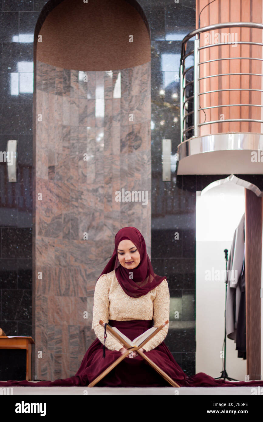 Young and beautiful girl sitting covered in sumptuous dress and teaches ...