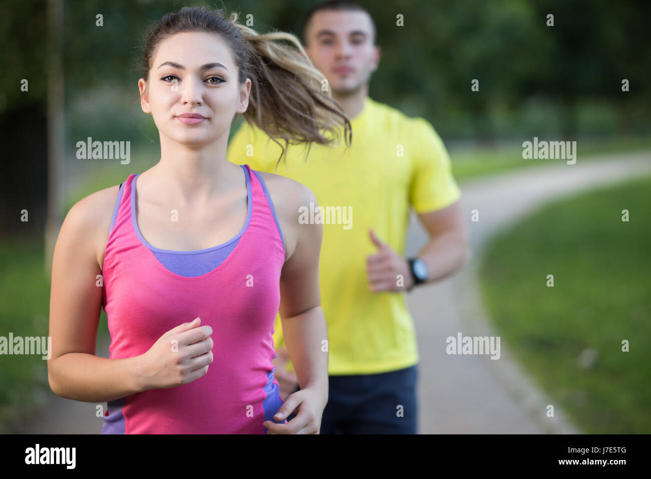 Couple stretching before jogging at the bench in the park Stock Photo ...