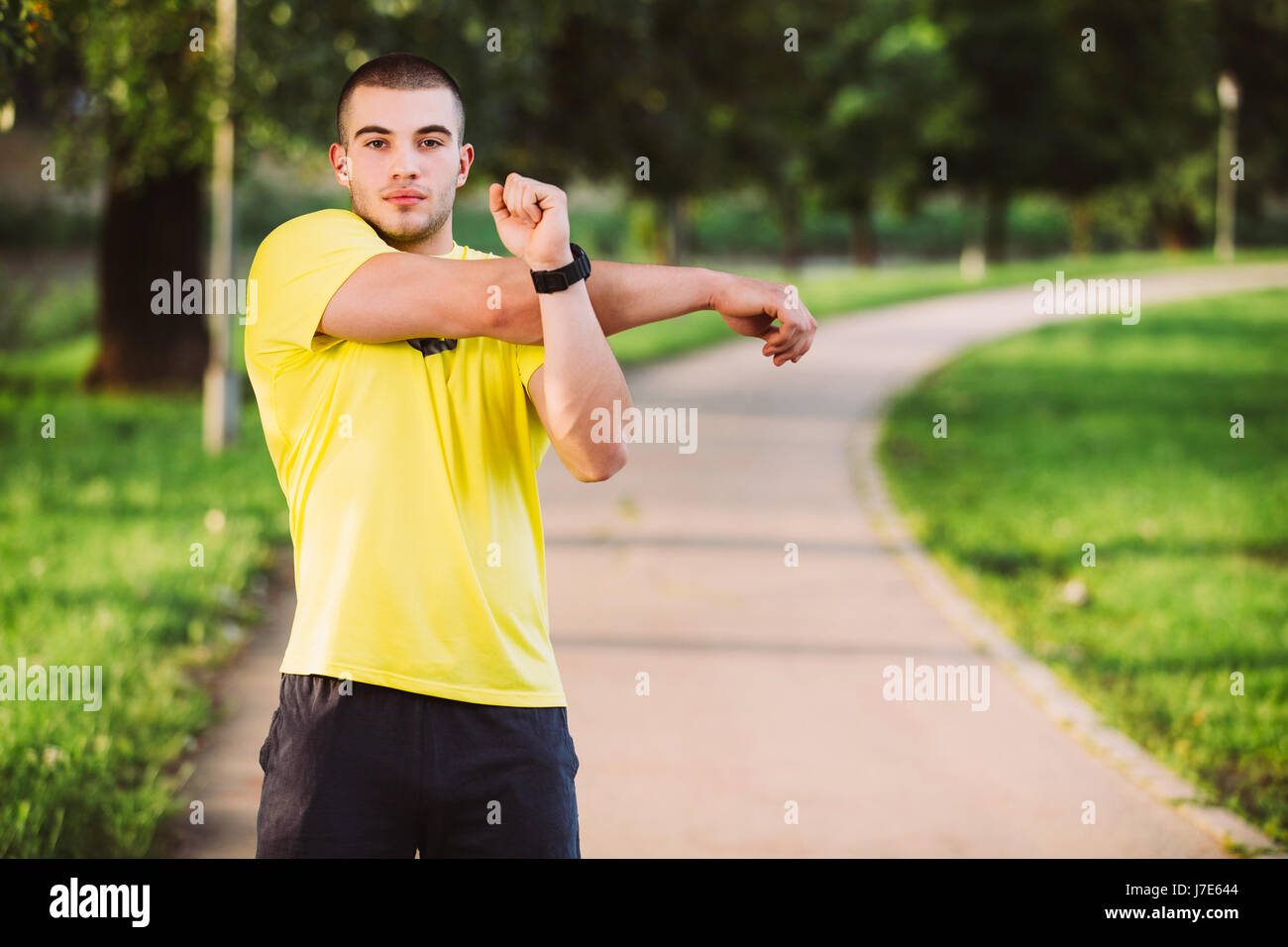 Fitness man stretching arm shoulder before outdoor workout. Sporty male ...