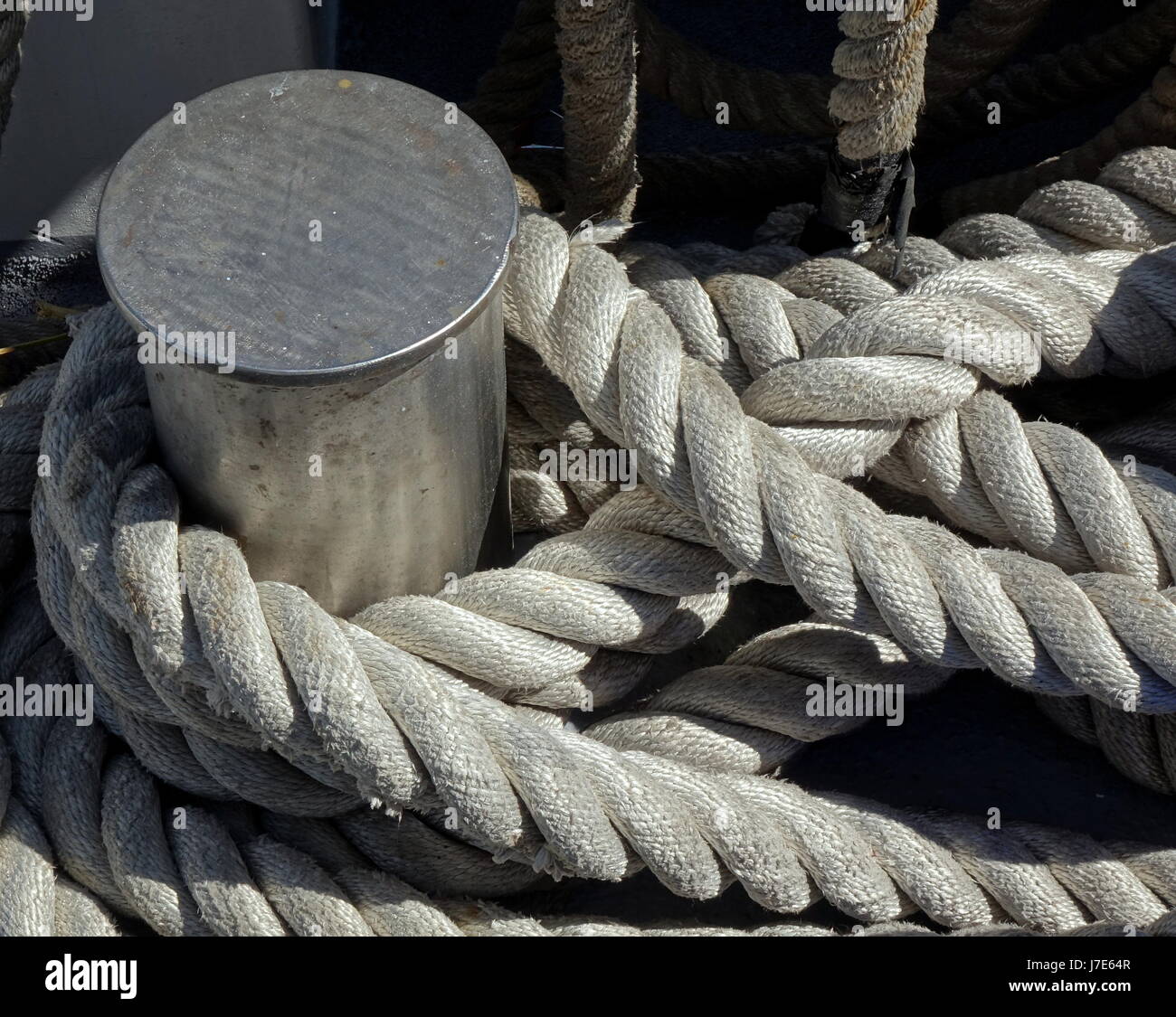 A steel mooring post with a thick rope wrapped around it Stock Photo ...