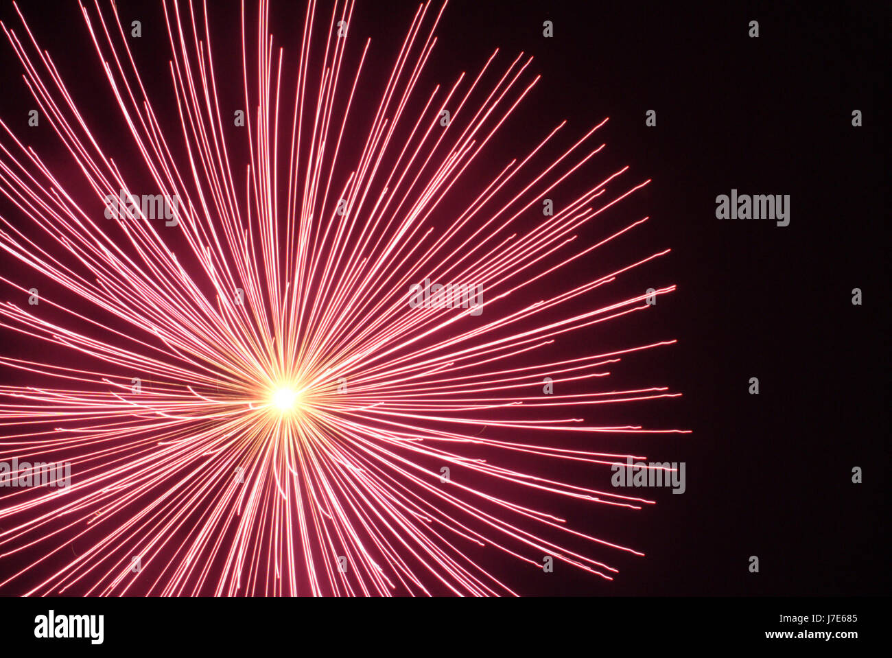 A single burst of red fireworks in the night sky Stock Photo - Alamy