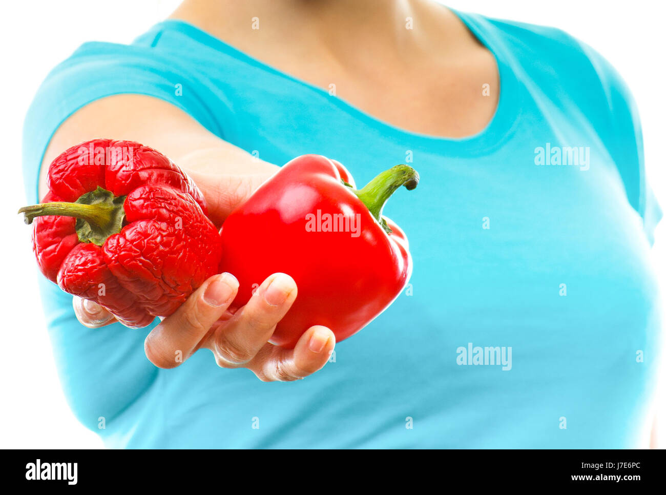 Woman holding in hand fresh and old wrinkled peppers, healthy and ...