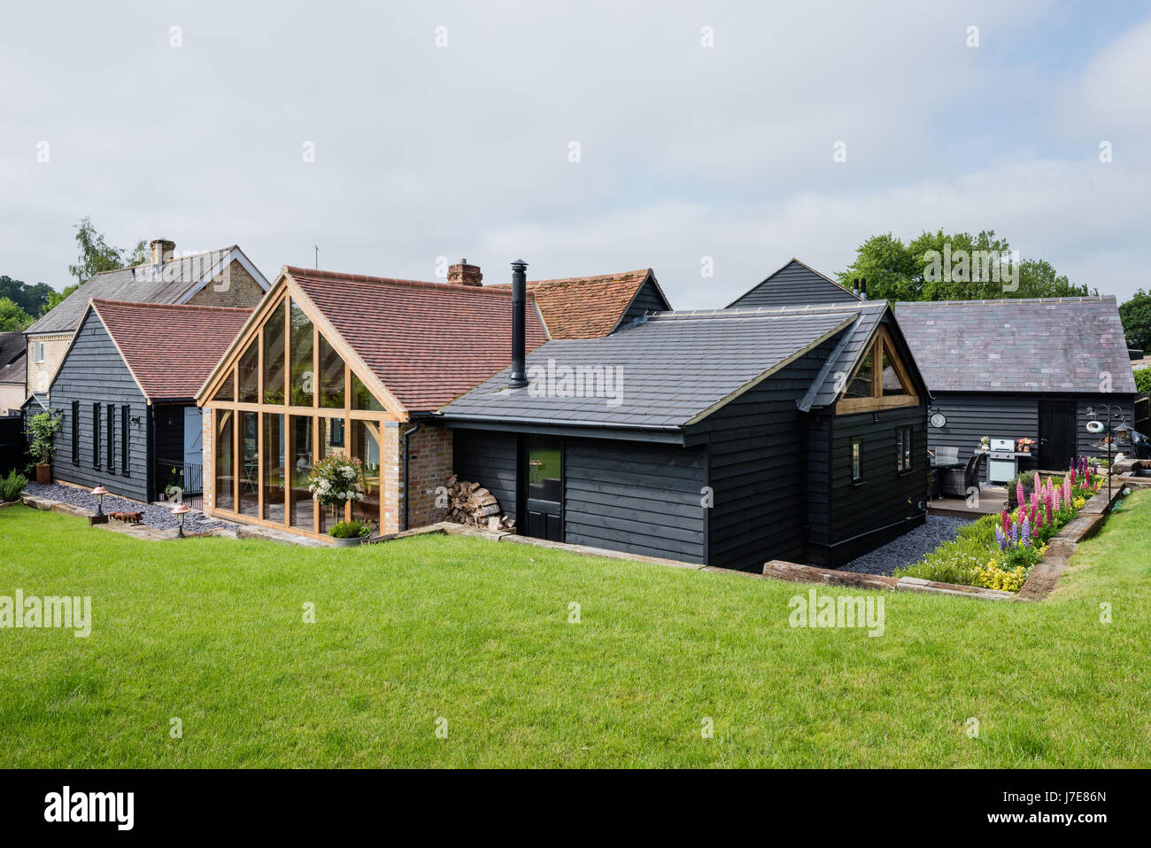 Exterior facade of converted barn and extension with wood cladding and ...