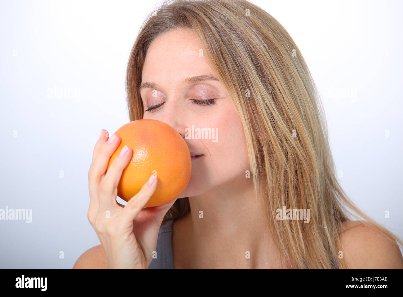 woman orange food aliment health closeup portrait wellbeing studio ...
